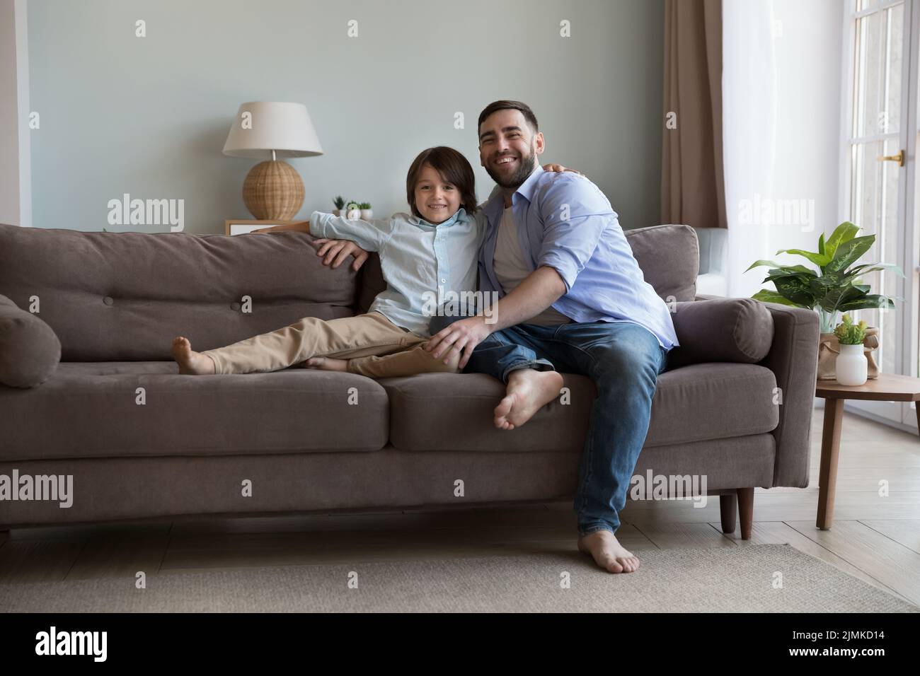 Little boy sit on sofa with young father at home Stock Photo - Alamy