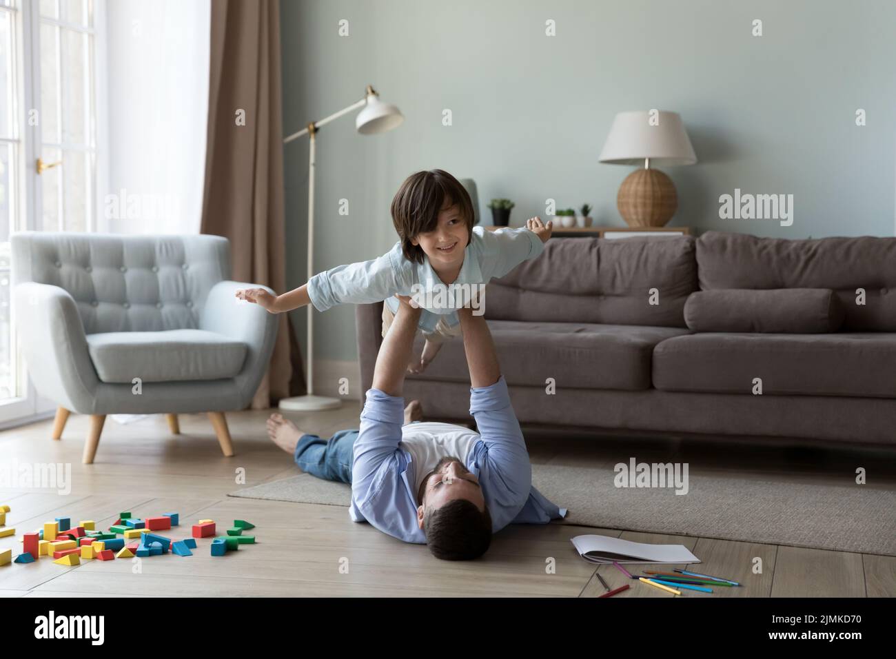 Young dad lift on stretched arms cute little son Stock Photo - Alamy