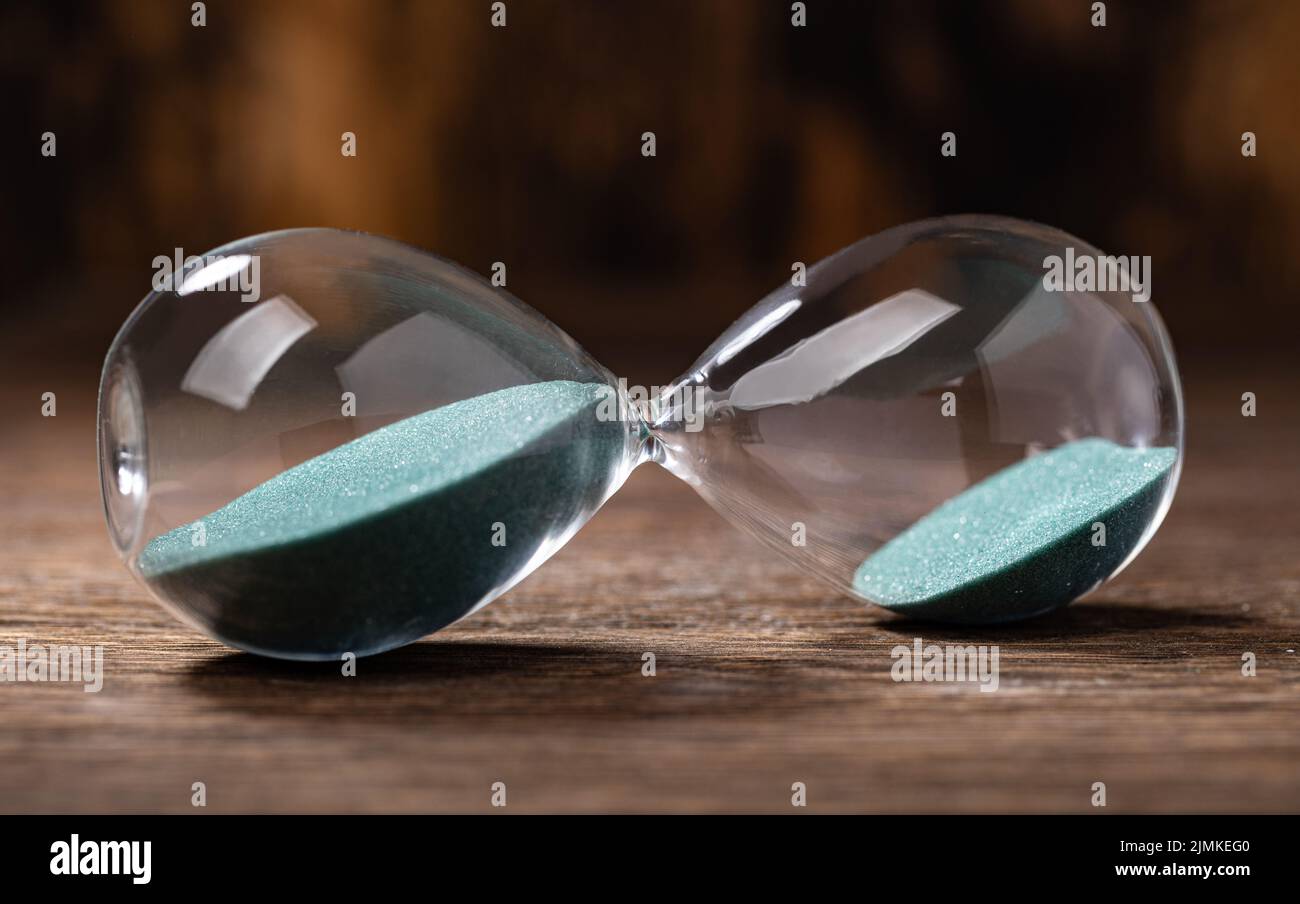 Hourglass with green sand Stock Photo - Alamy