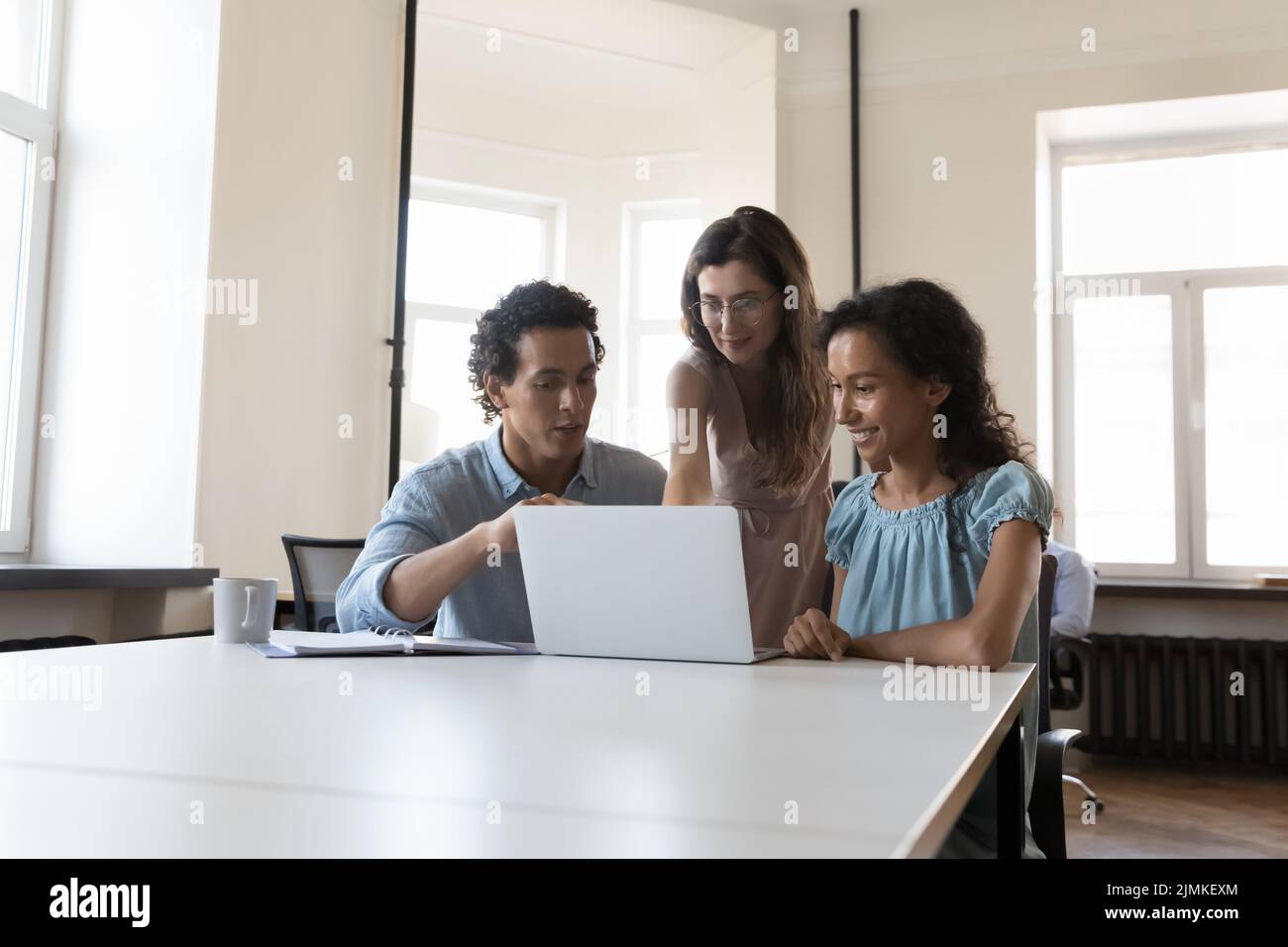 Multiethnic teammates look at laptop screen working on corporate task ...
