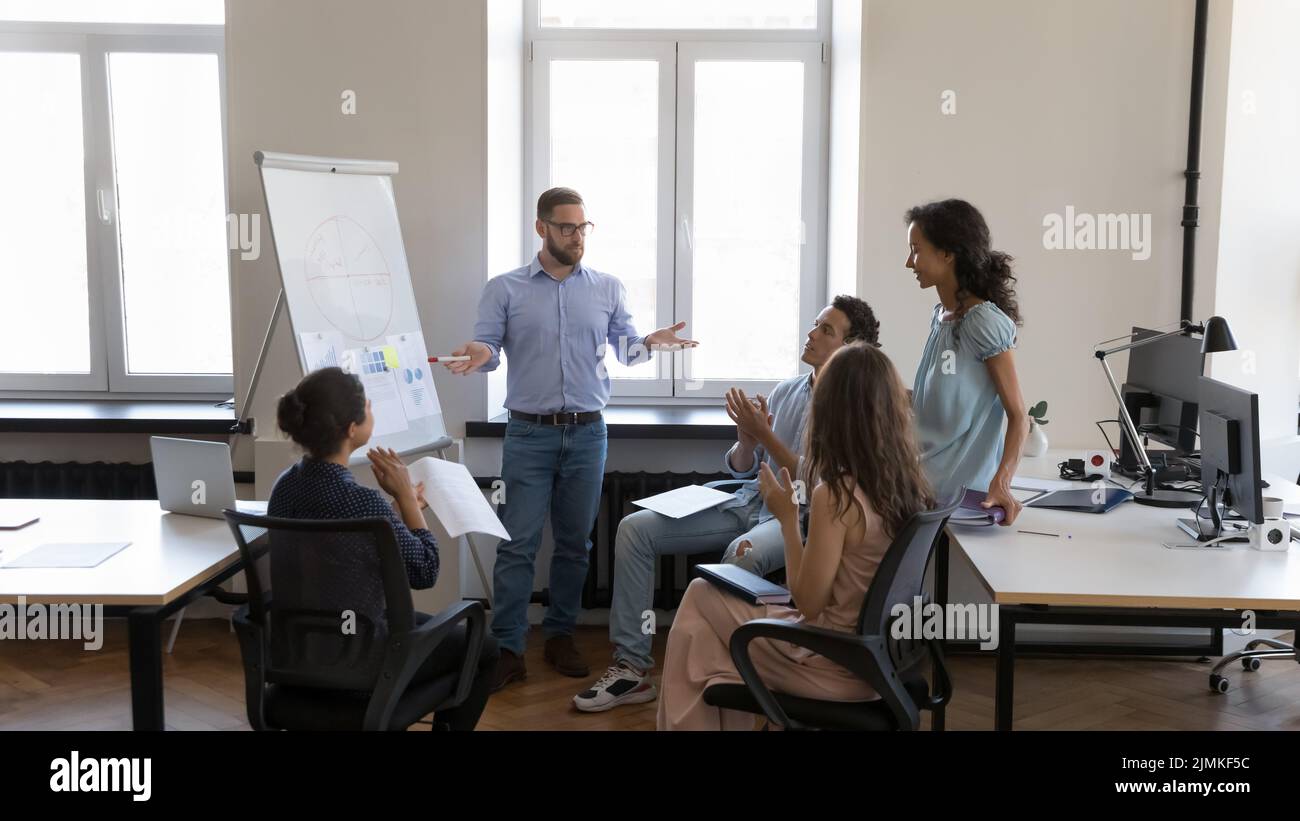 Diverse employees attending at teambuilding meeting led by man coach ...