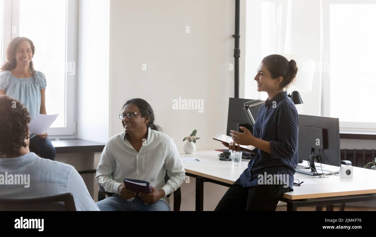 Indian and diverse colleagues communicating in coworking space Stock ...