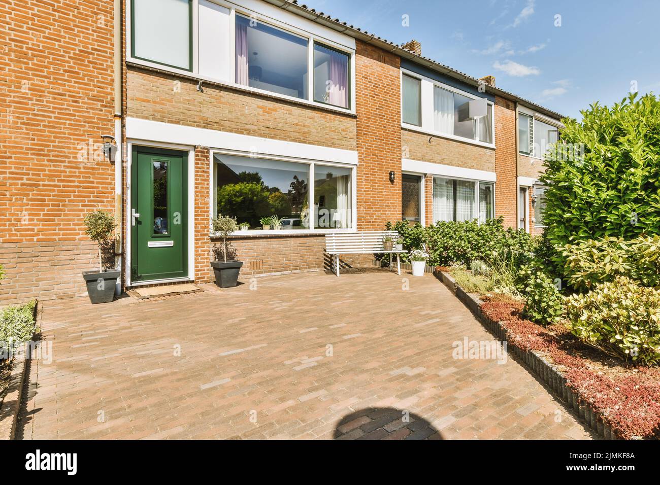 The front view of a brick building with signs,pavement and wooden doors ...