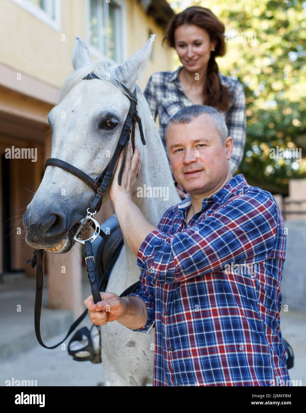 Man trainer teach to female while riding horse at ranch Stock Photo - Alamy