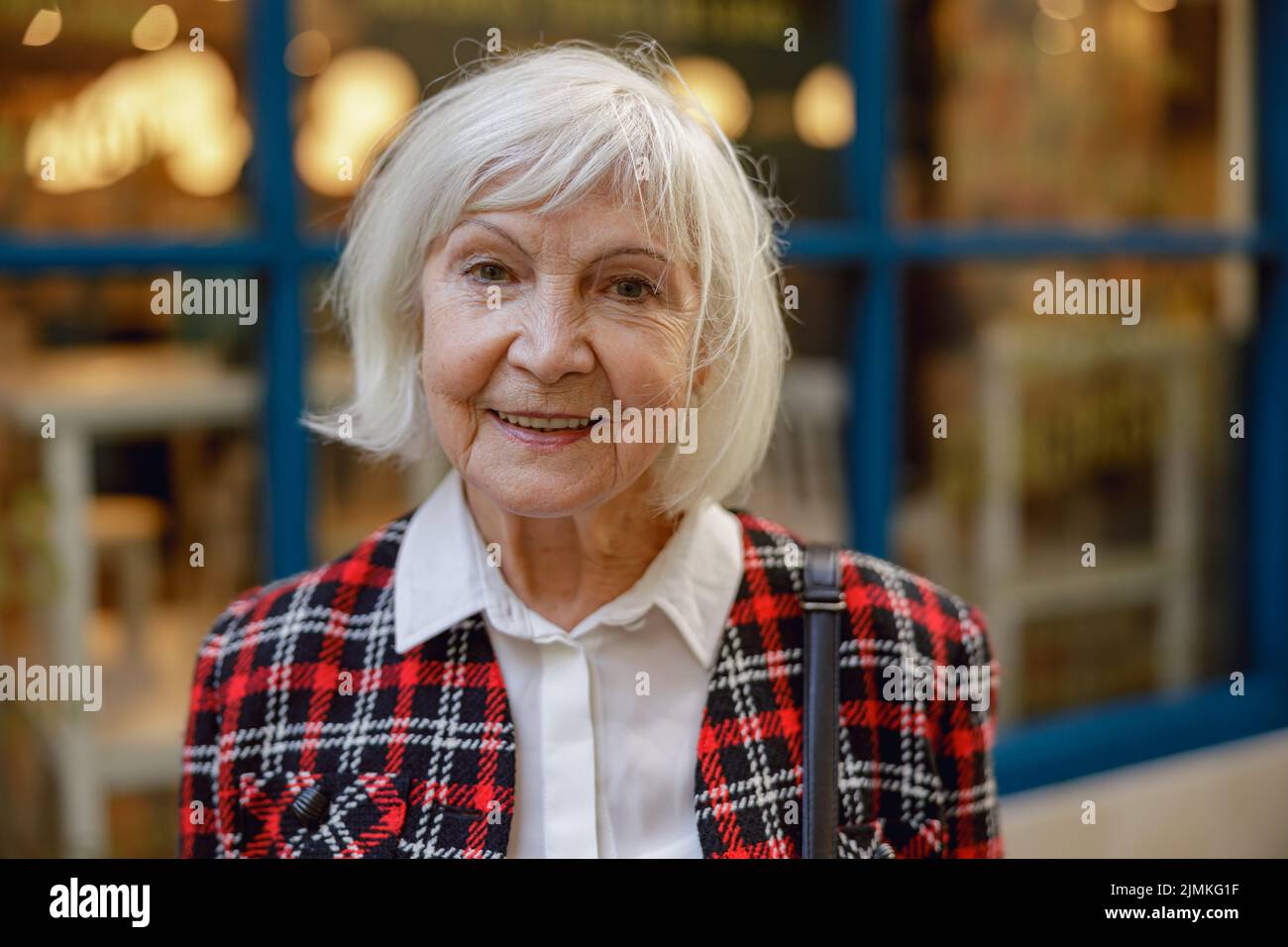 Happy retired woman smiling while standing outdoors Stock Photo - Alamy