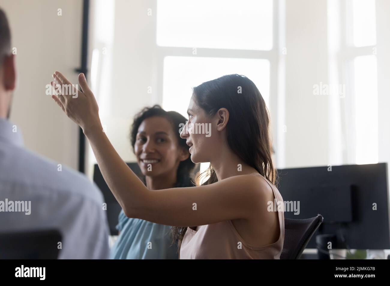 Employee raising hand, asking question to mentor at group meeting Stock ...