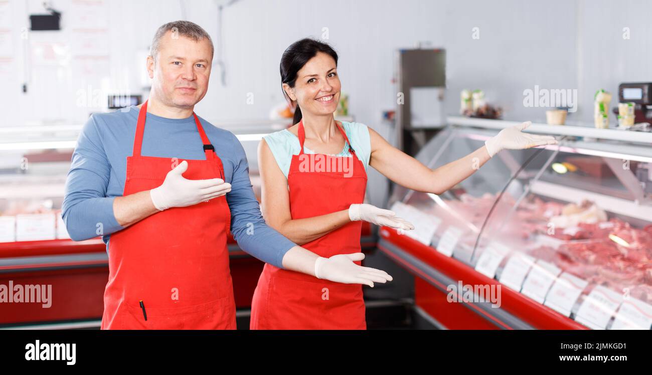 Man and woman seller offering products in shop Stock Photo - Alamy