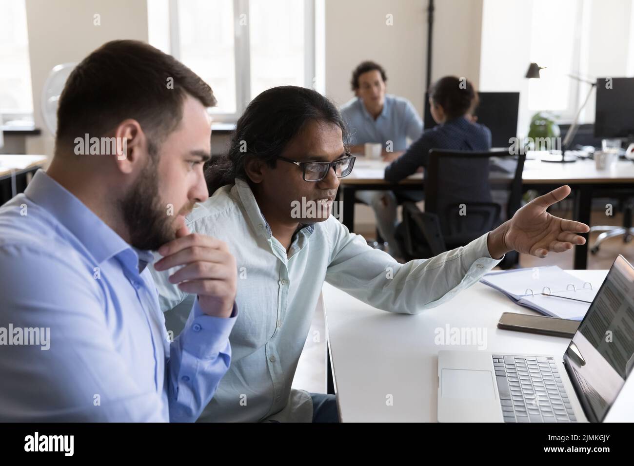 Skilled Indian employee explain corporate software to colleague use ...