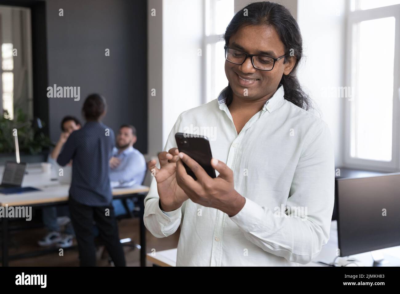 Indian office employee use smartphone during beak in coworking Stock ...