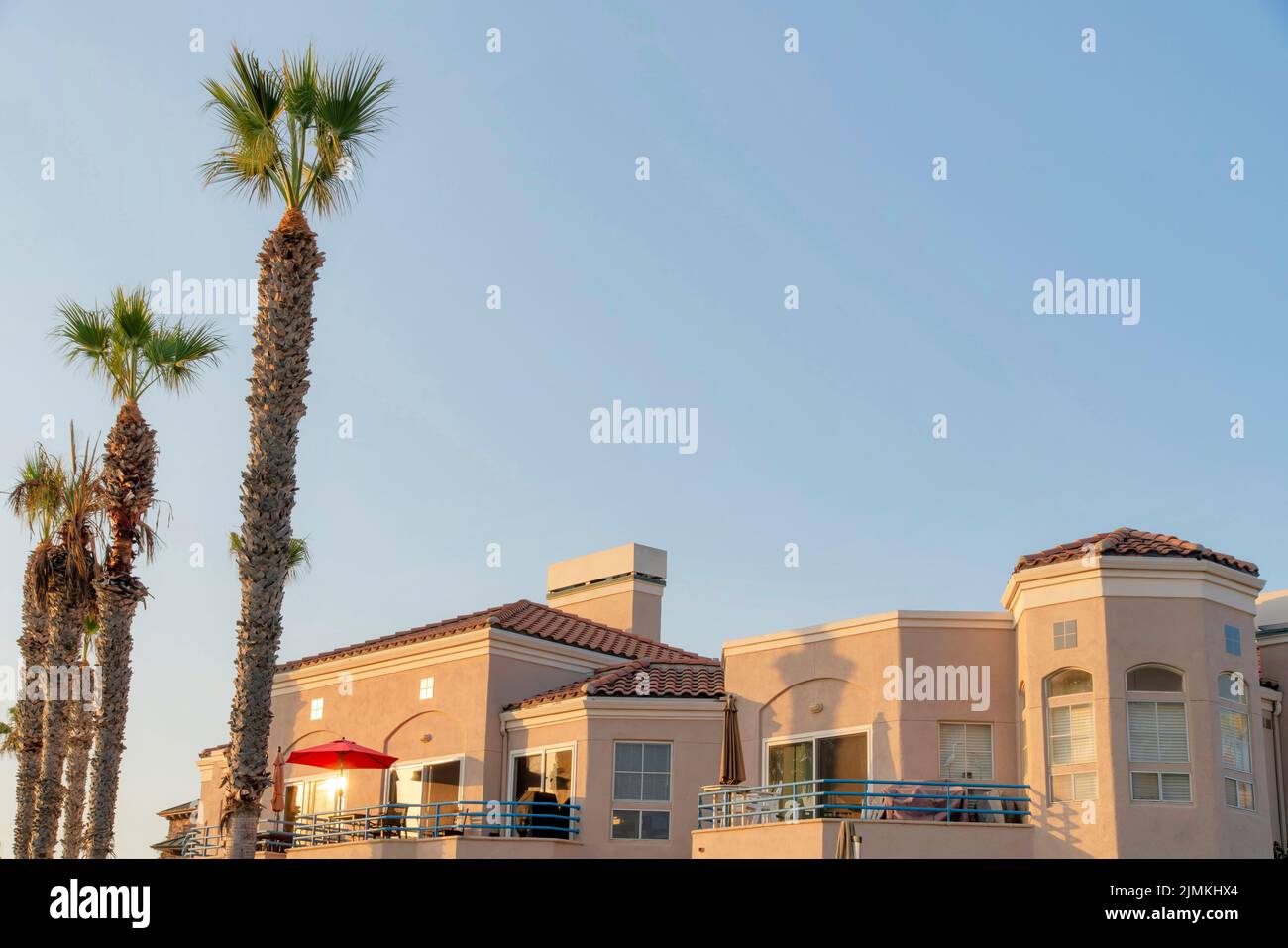 Mediterranean style hotel building with palm trees outside at Oceanside ...