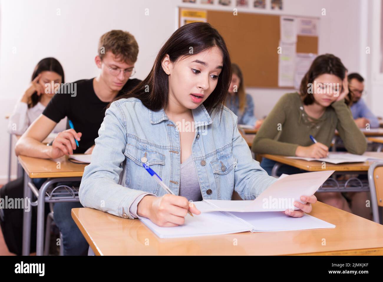 schoolgirl is sitting test and answer about task Stock Photo - Alamy