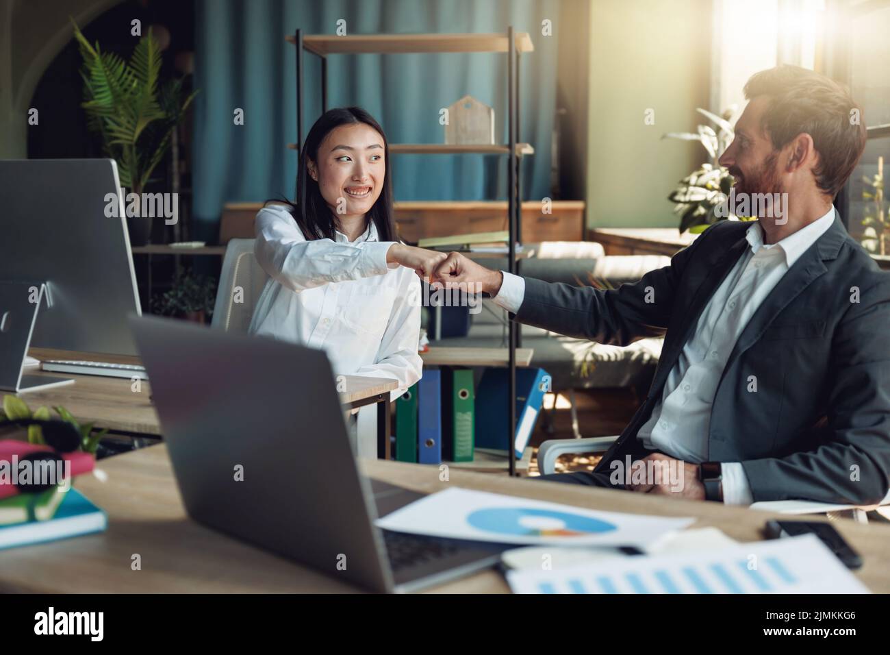 Two happy business colleagues clap hands after finishing work on ...