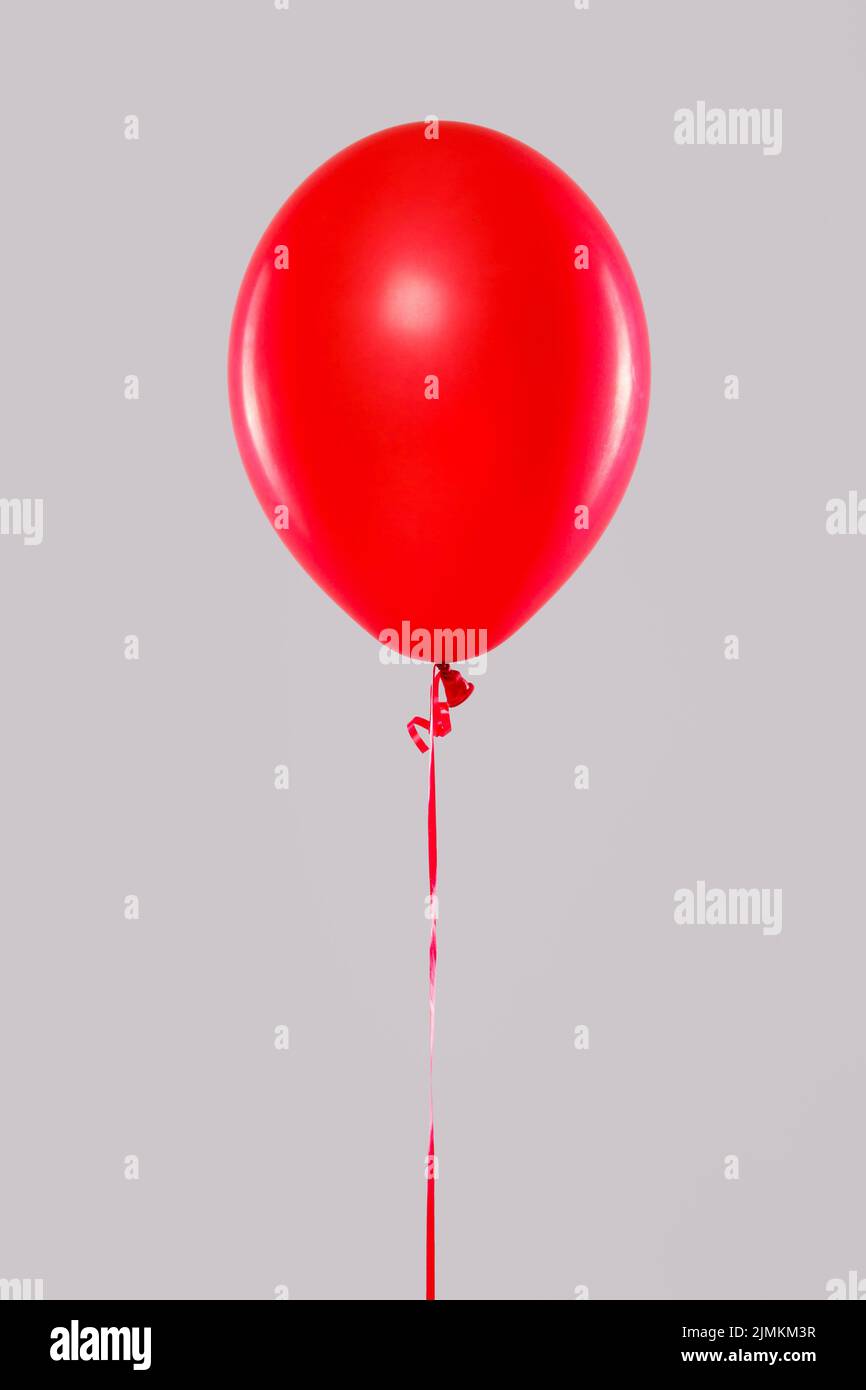 One red balloon isolated on gray background Stock Photo - Alamy