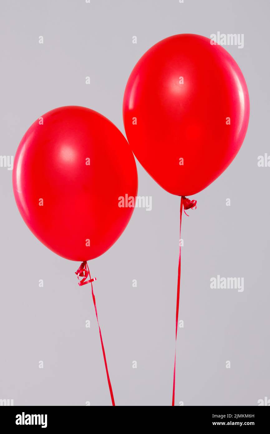Two red balloons isolated on gray background Stock Photo - Alamy