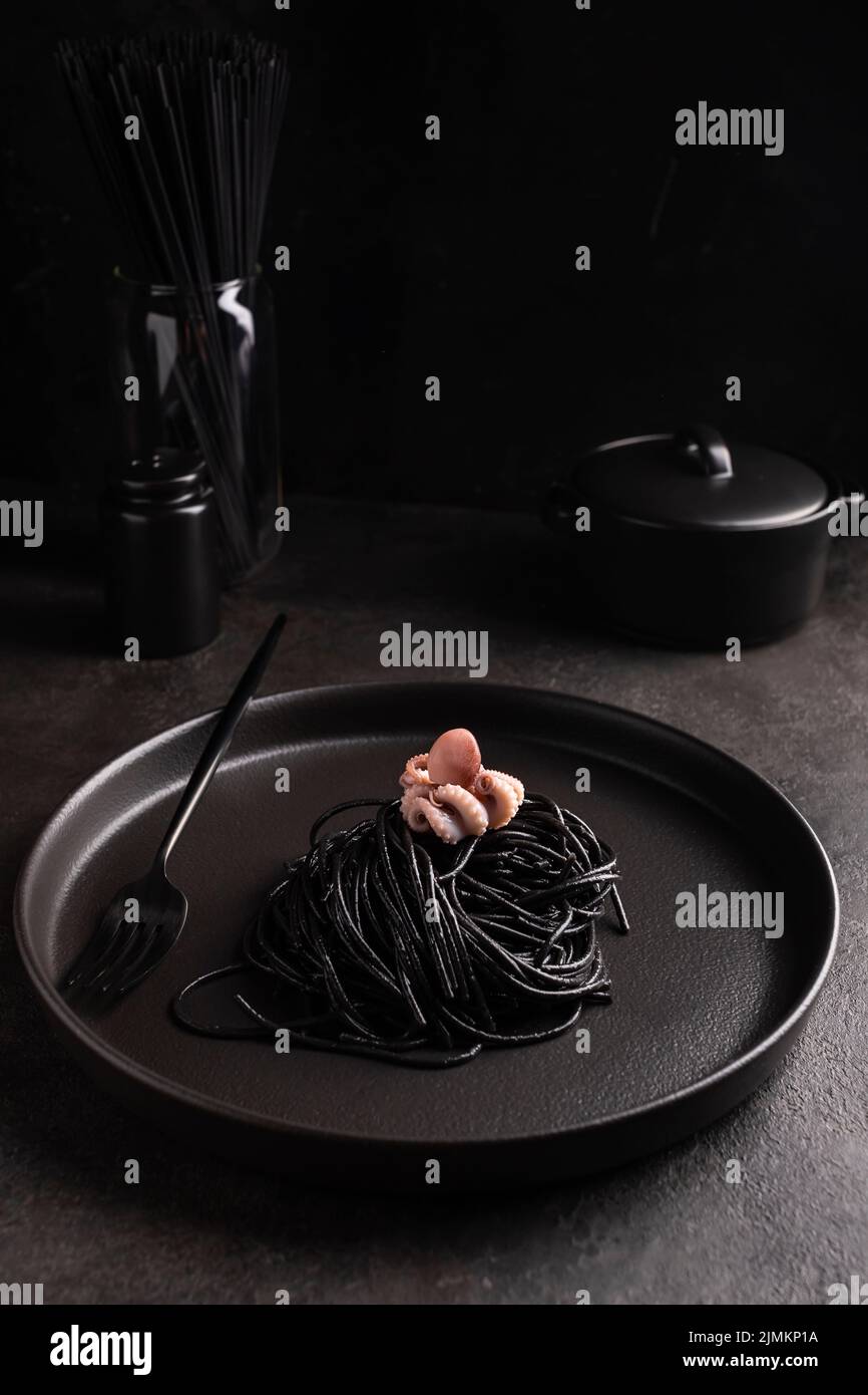 Black spaghetti with cuttlefish ink with boiled octopus Stock Photo - Alamy