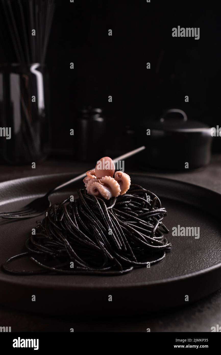 Black spaghetti with cuttlefish ink with boiled octopus Stock Photo - Alamy