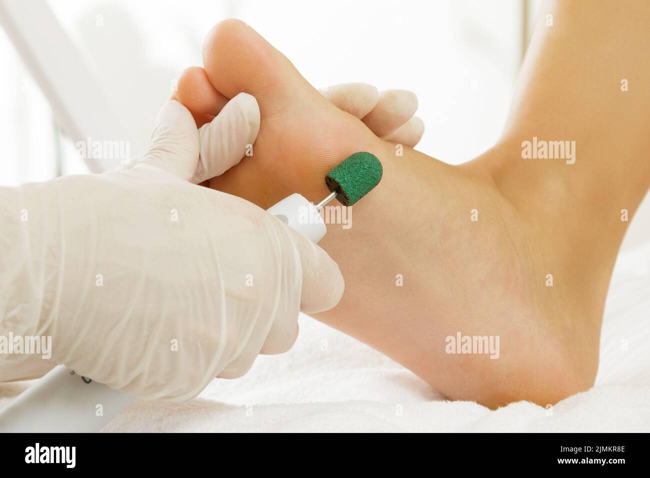 Pedicure master work. Closeup of female feet and hands in gloves with a ...
