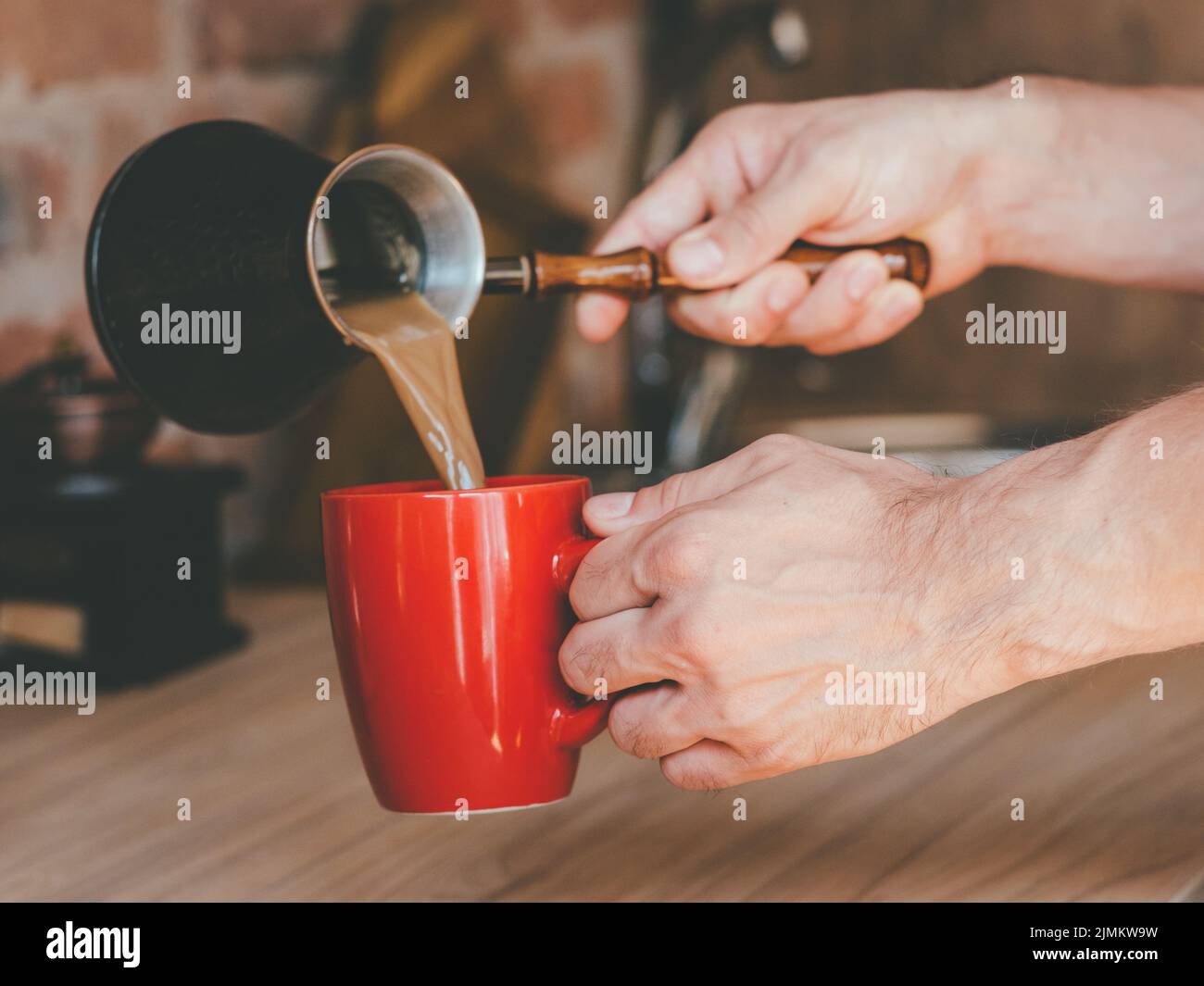 coffee time man jezve pouring latte red mug Stock Photo - Alamy