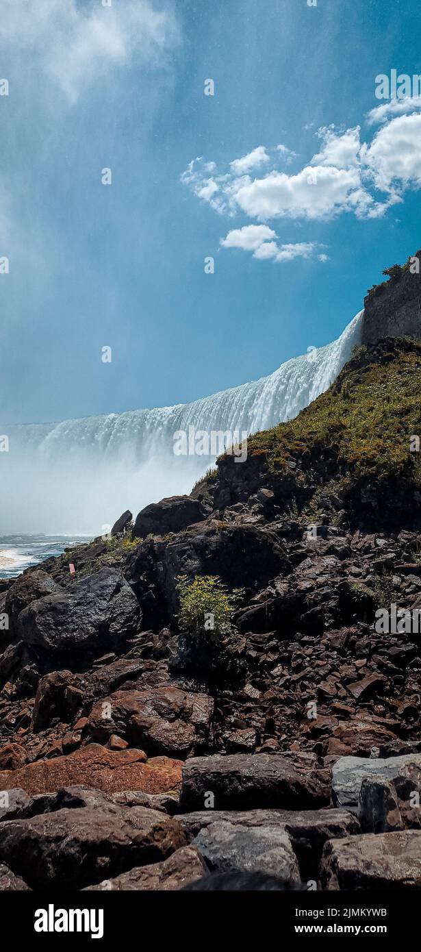 Vertical shot of a rocky slope with the magnificent Niagara Falls in ...