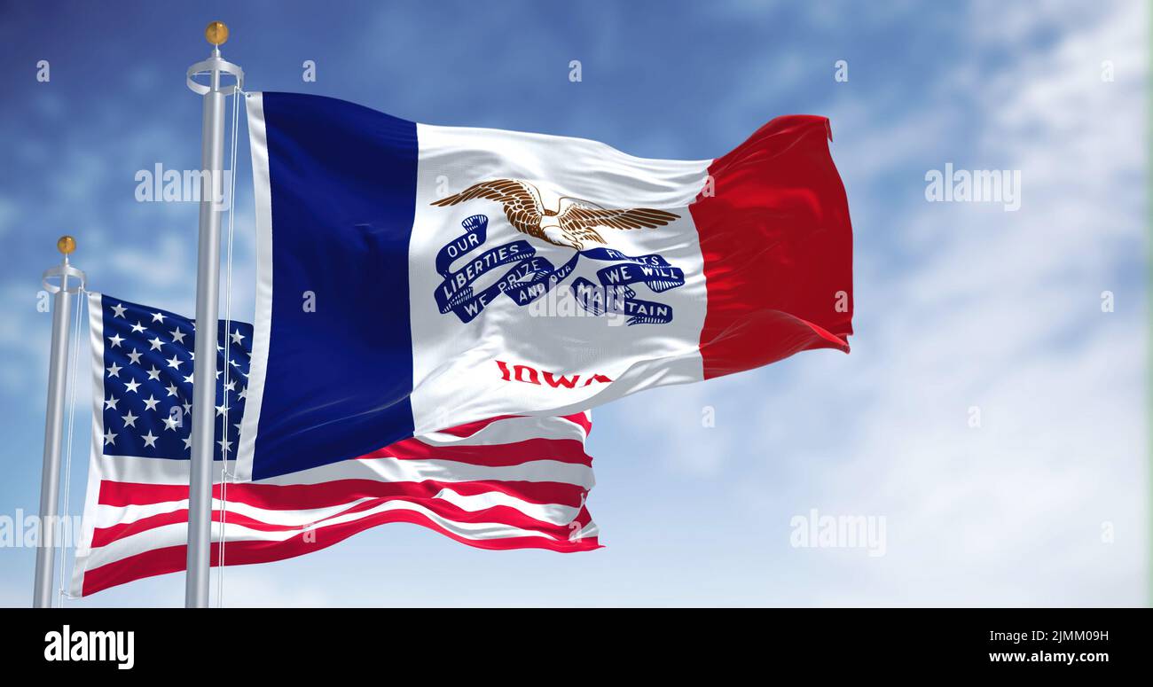 The Iowa state flag waving along with the national flag of the United ...