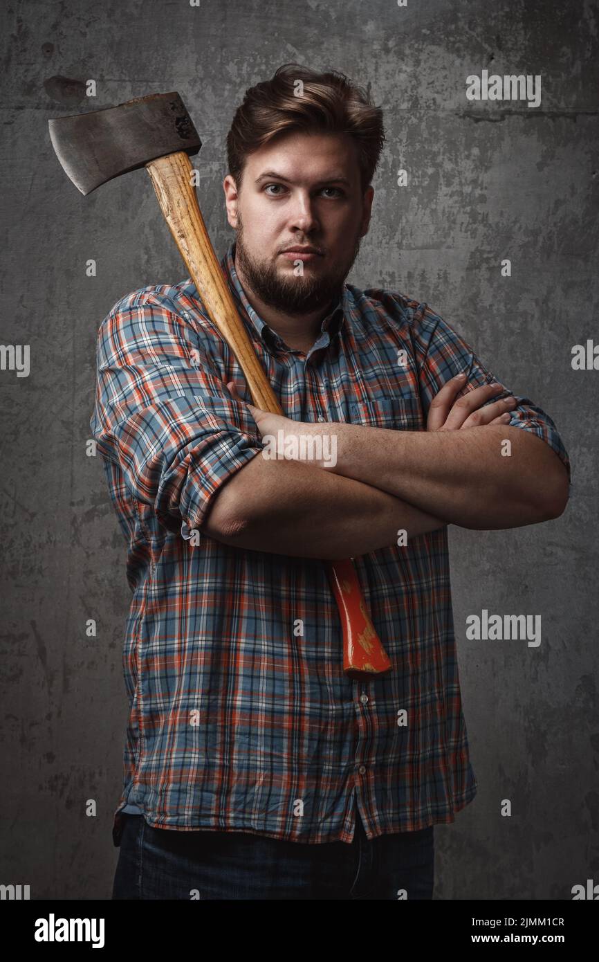 Bearded man with axe posing in studio Stock Photo - Alamy