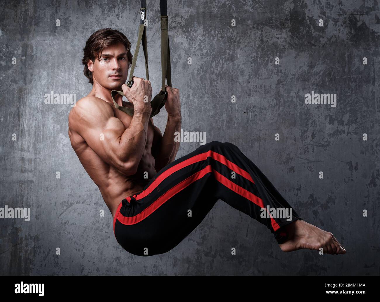 Muscular man during workout with suspension straps Stock Photo - Alamy