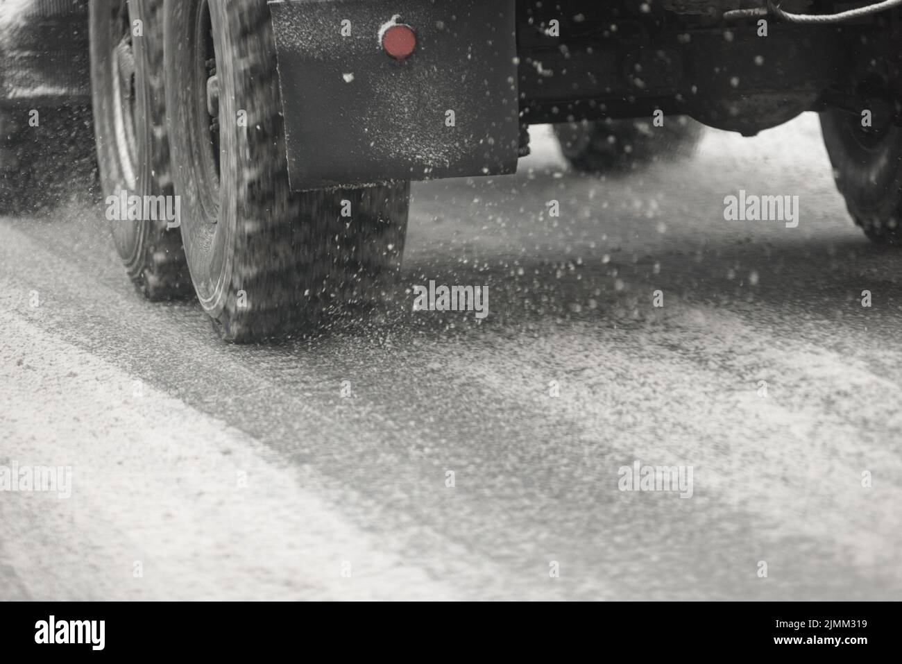 Road snow pieces flow from wheels of russian military truck moving on ...