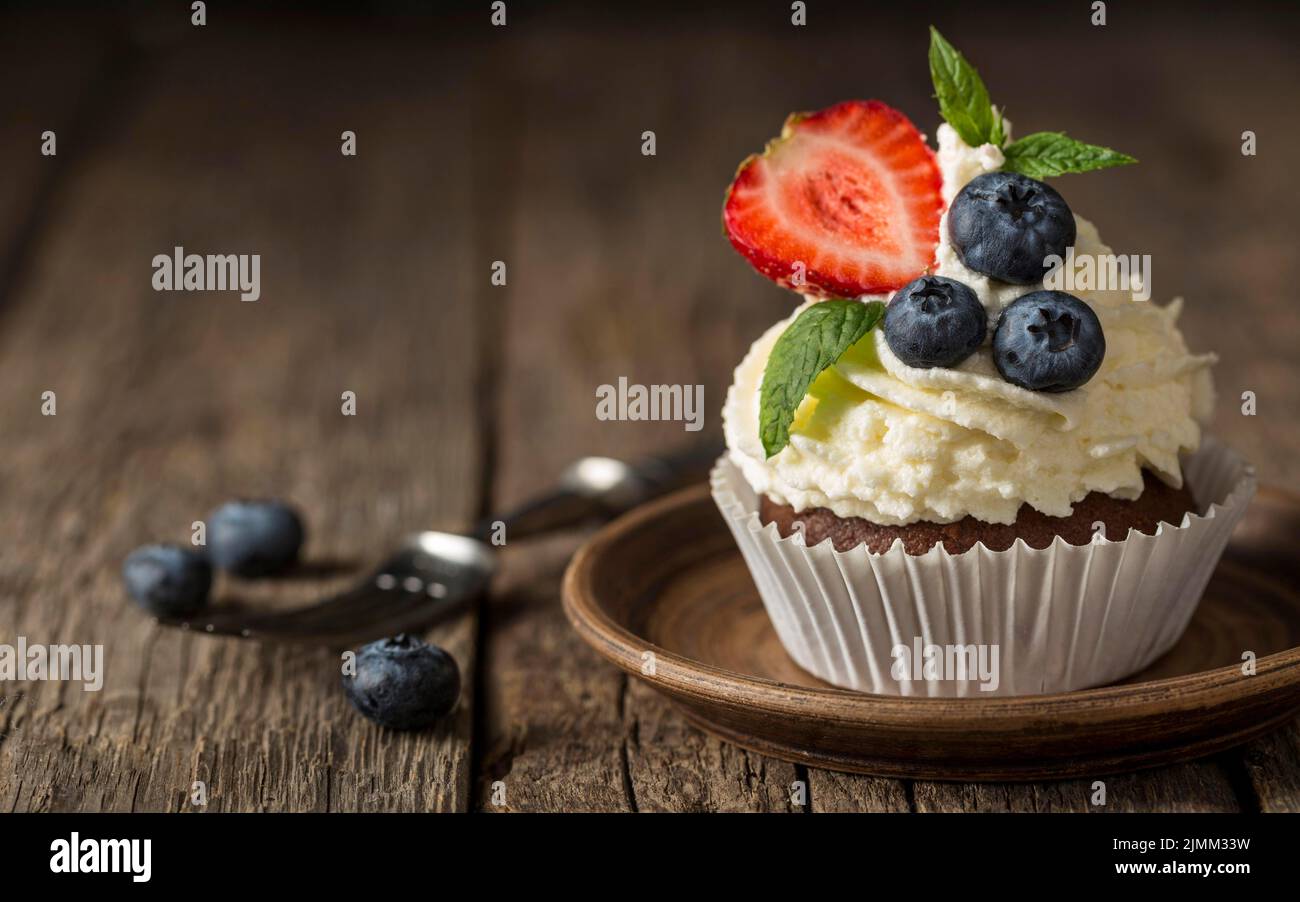 Front view view tasty cupcake with strawberry blueberry Stock Photo - Alamy