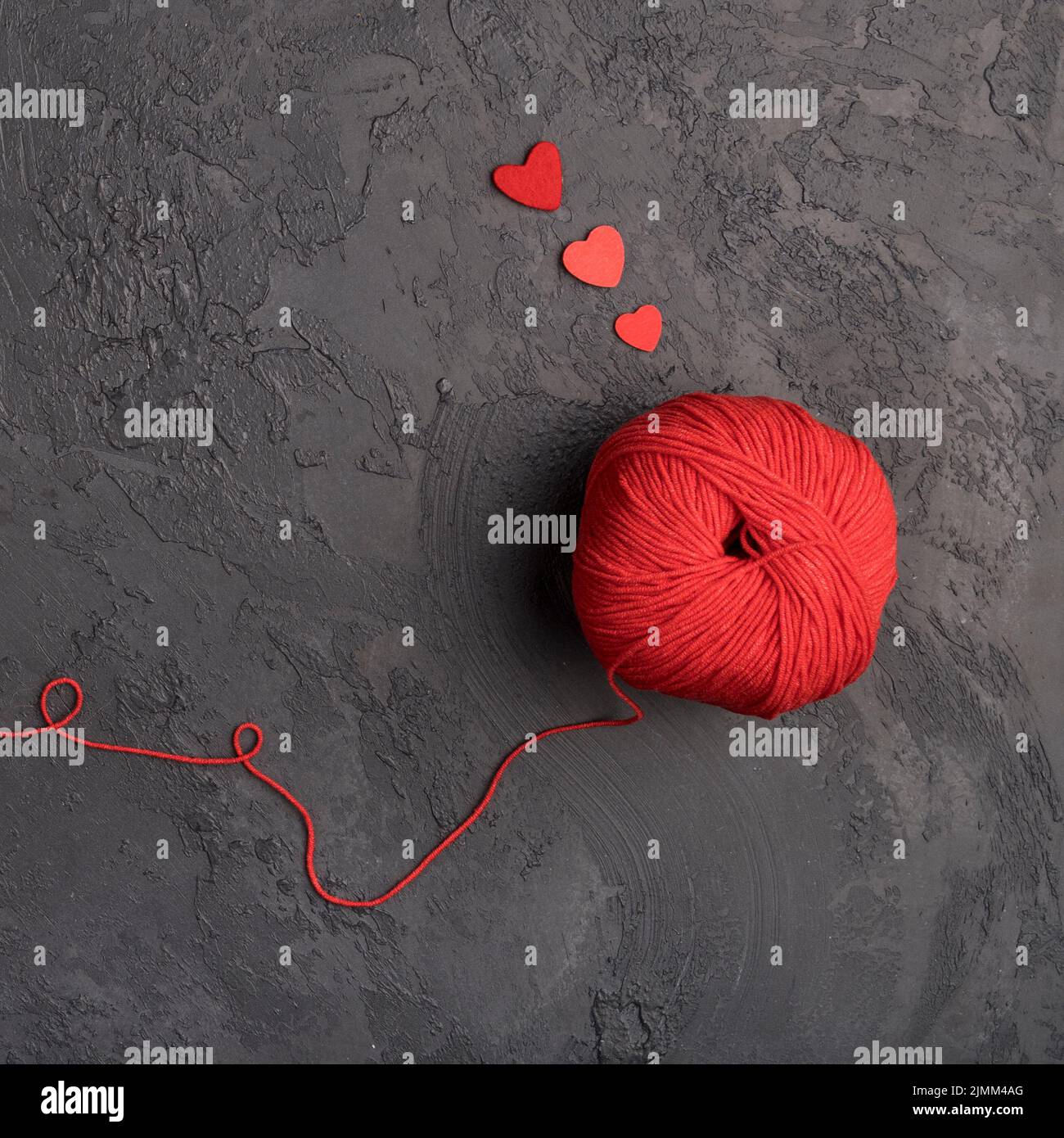 Red wool ball slate background Stock Photo - Alamy