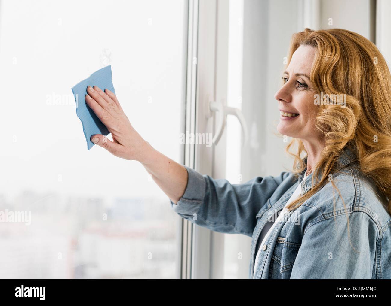 Woman wiping window with rag Stock Photo - Alamy