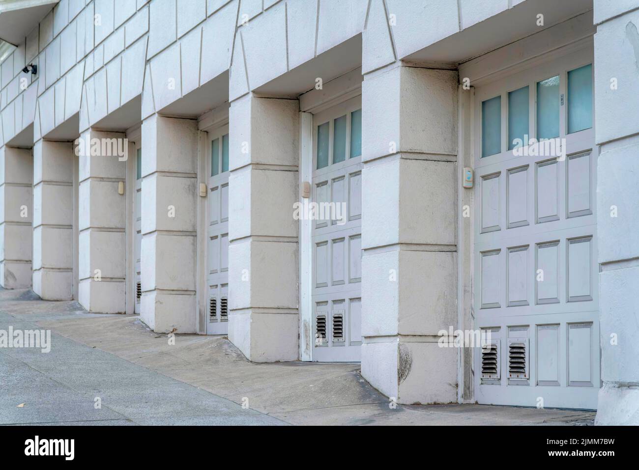Row of garage doors on a sloped road of an old apartment building at ...