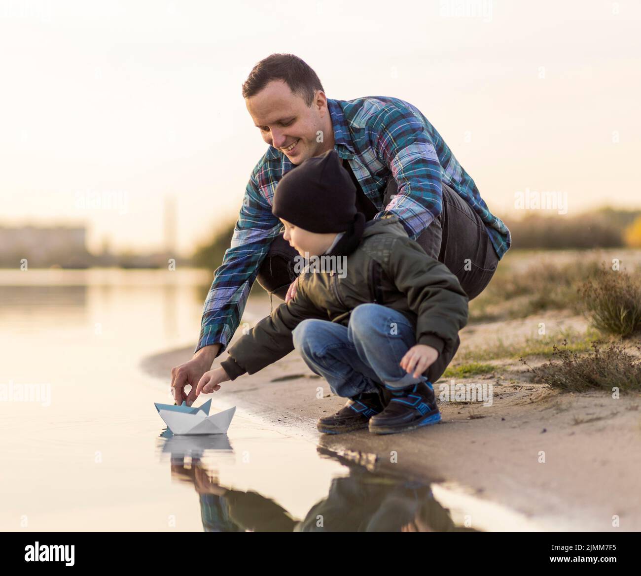 Father son playing with origami boat Stock Photo - Alamy