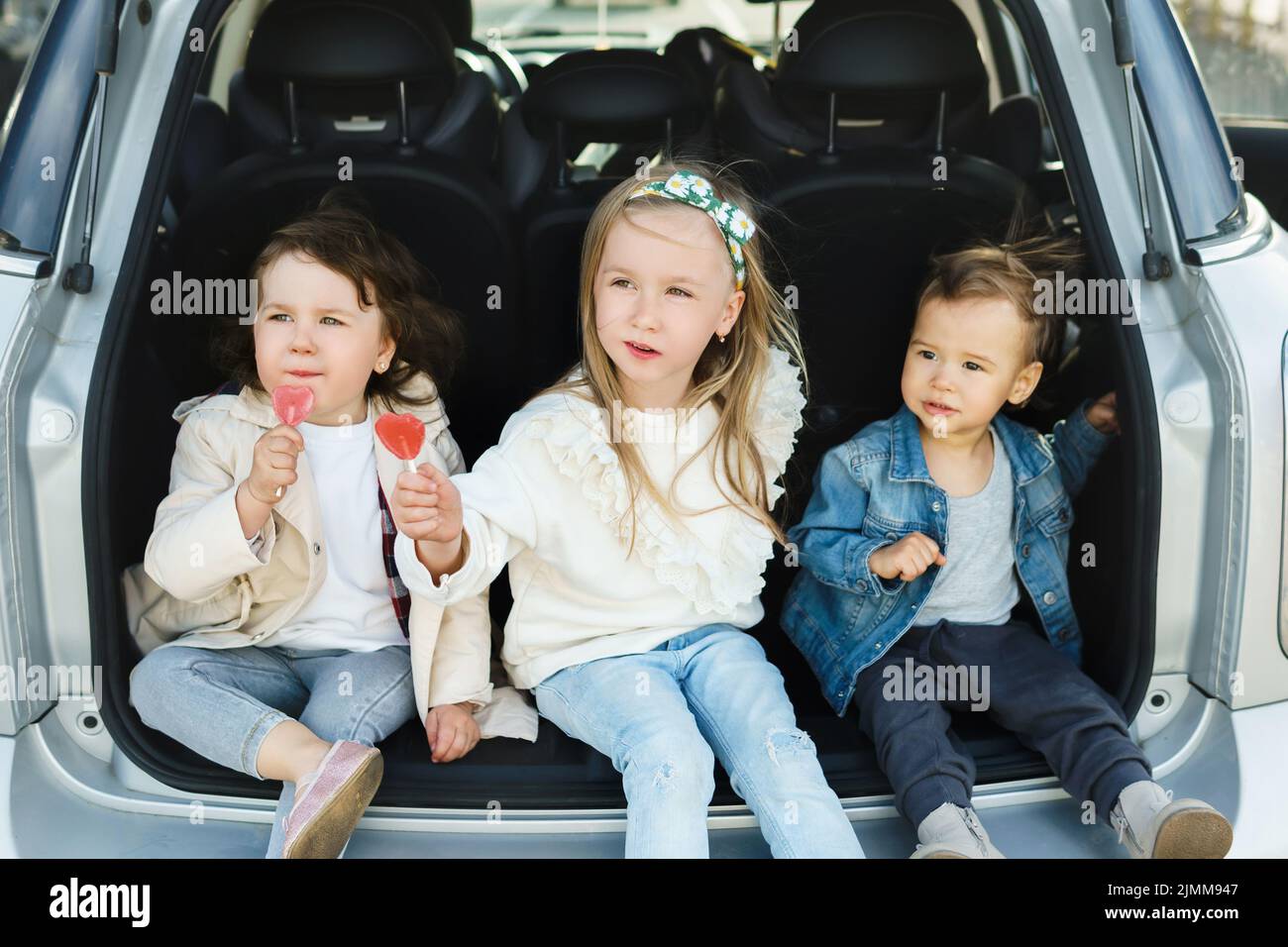 Little kids sitting in a car's trunk before a road trip Stock Photo - Alamy