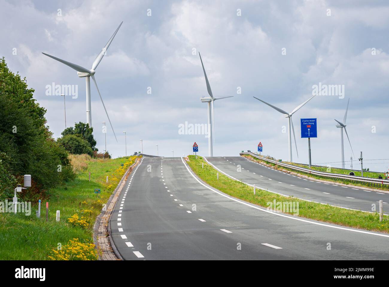 Perspective view of a highway road seeming to lead to windturbines in ...