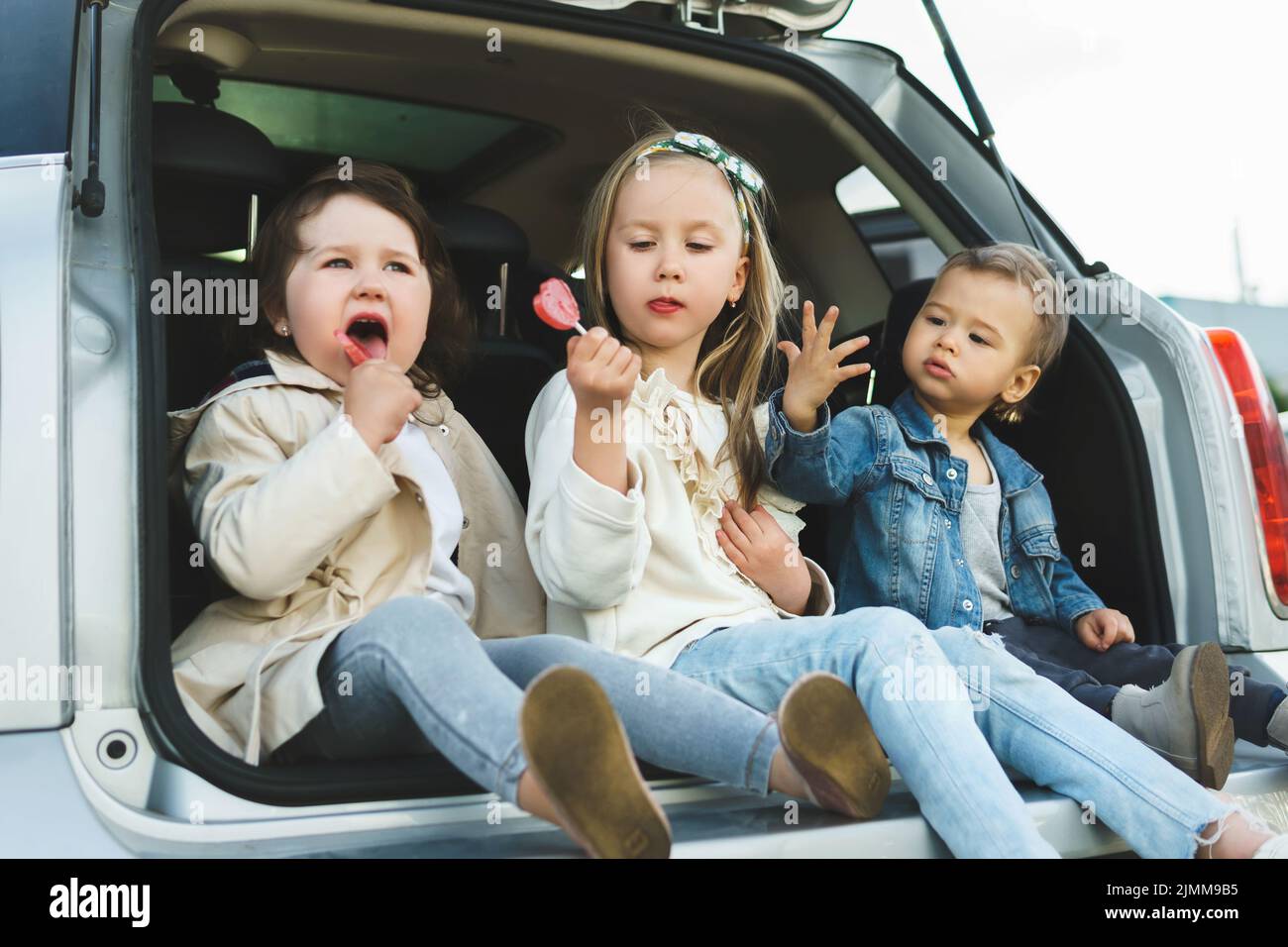 Little kids sitting in a car's trunk before a road trip Stock Photo - Alamy