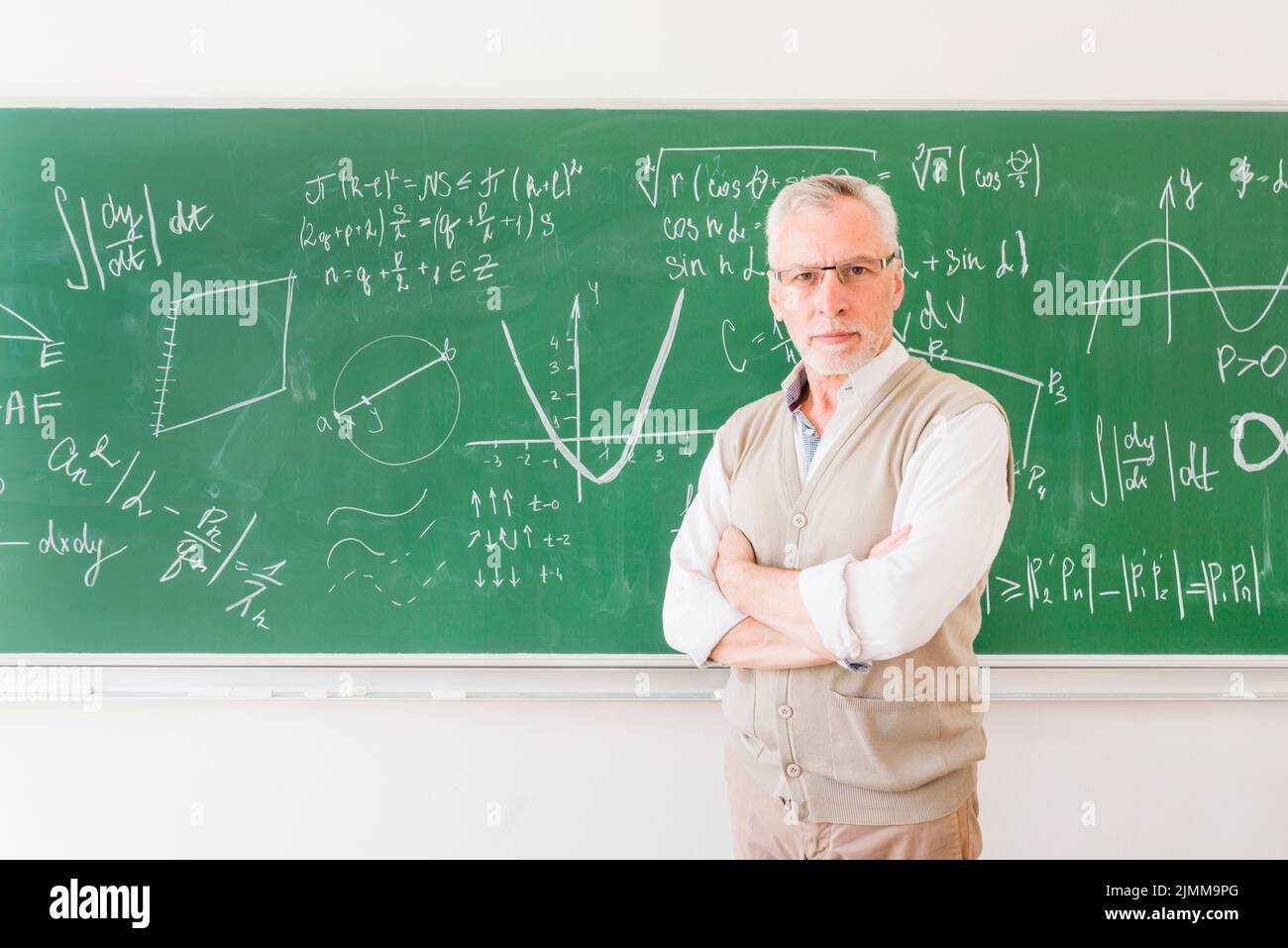 Elder professor standing near chalkboard classroom Stock Photo - Alamy