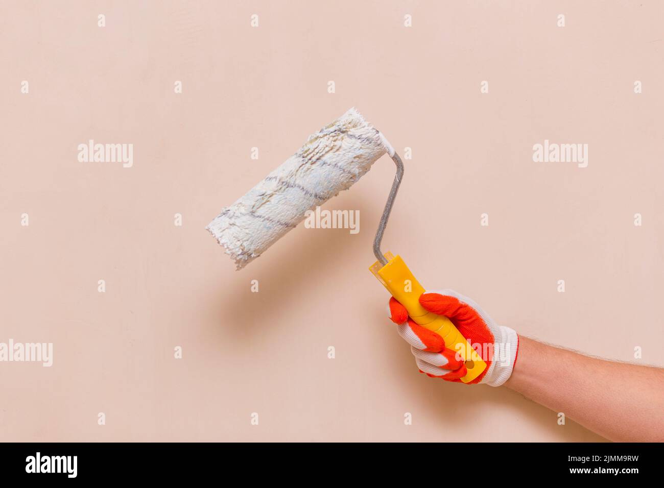 Front view hand holding paint roller Stock Photo - Alamy