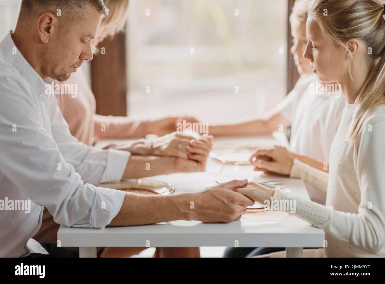 Family praying before eating Stock Photo - Alamy