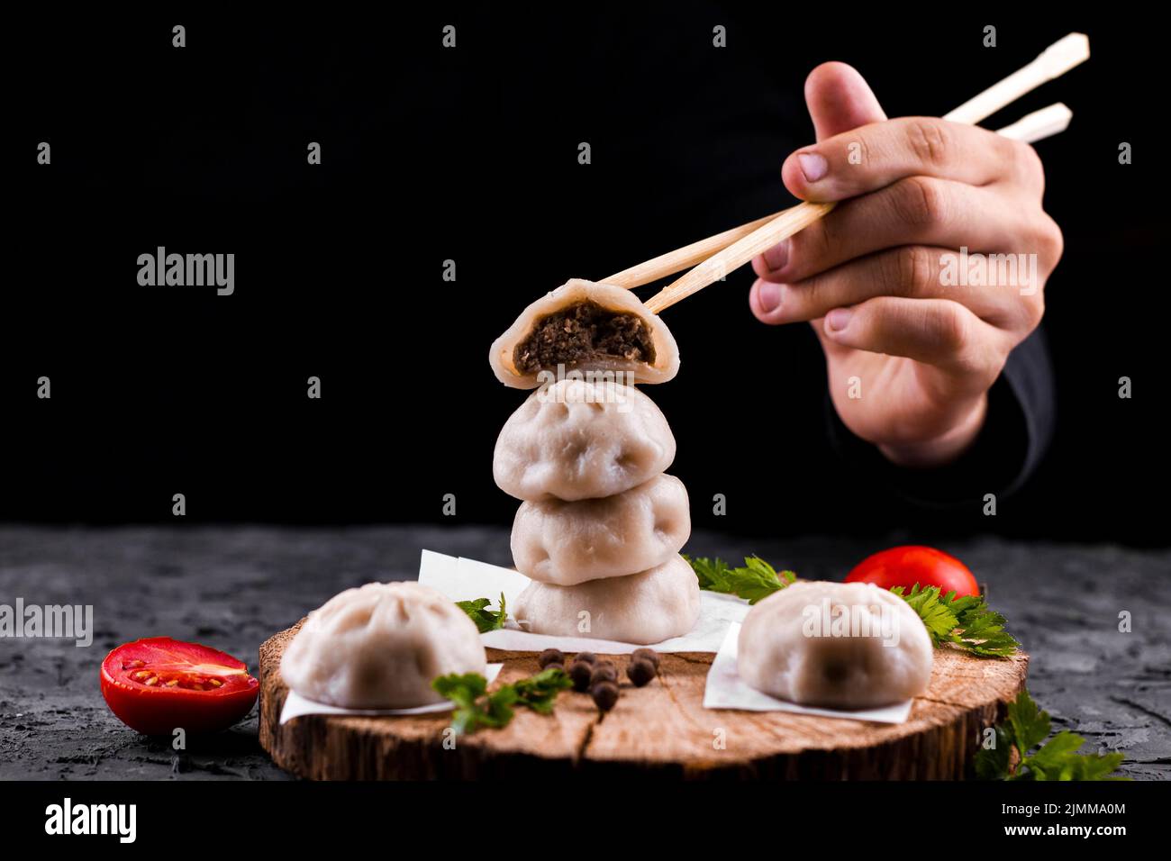 Hand holding chopsticks with dumpling Stock Photo - Alamy