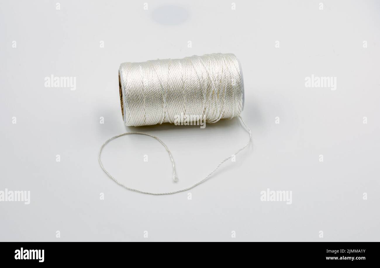 spool of white thread closeup on white Stock Photo - Alamy