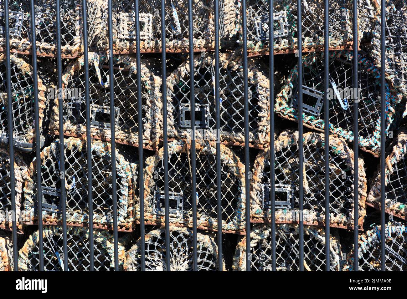 Close up on a stack of Lobster pots behind steel fence railings Stock ...