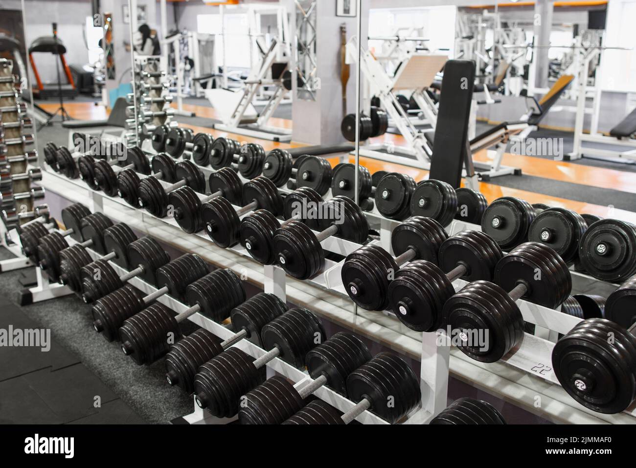 Rack with dumbbells at gym interior Stock Photo - Alamy