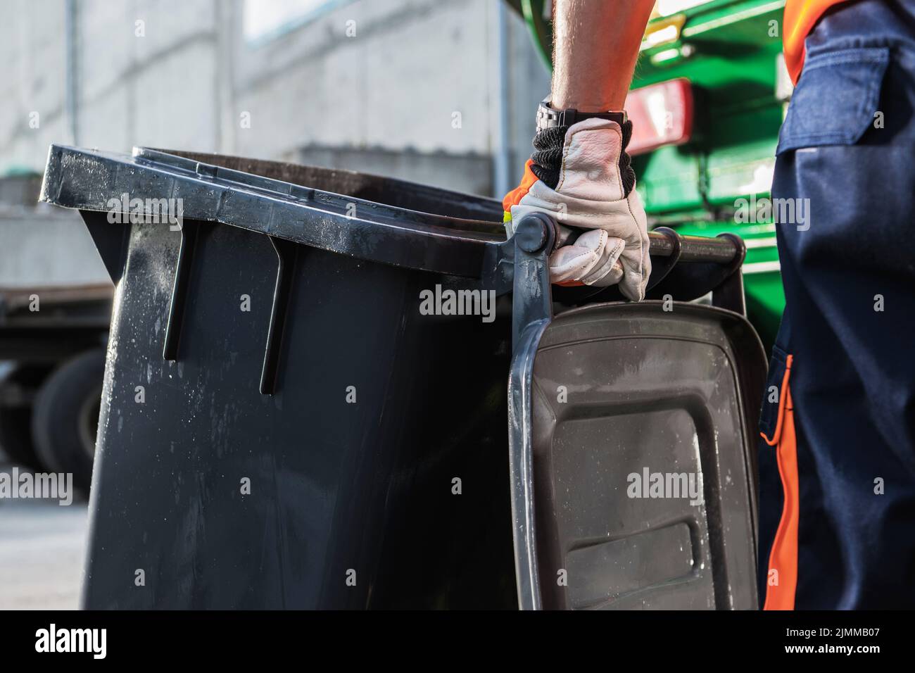 Garbage Truck Worker Moving Clean Black Trash Can Close Up. Waste ...