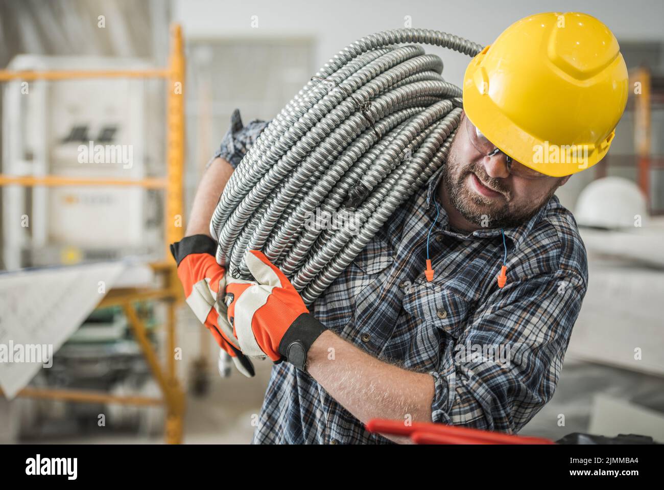 Closeup of Caucasian Contractor in Yellow Safety Helmet Putting Efforts ...