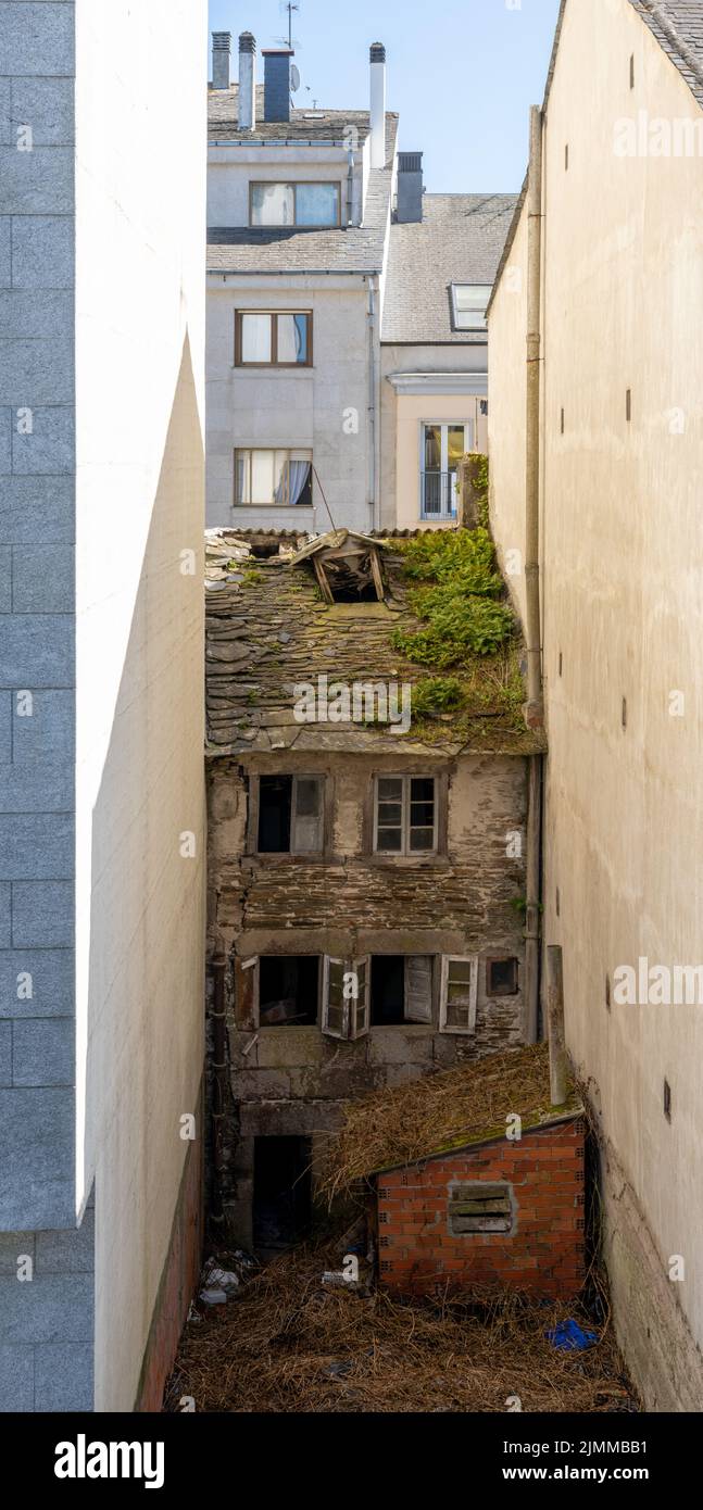 Old house ruin squeezed in between new buildings in downtown Lugo Stock ...
