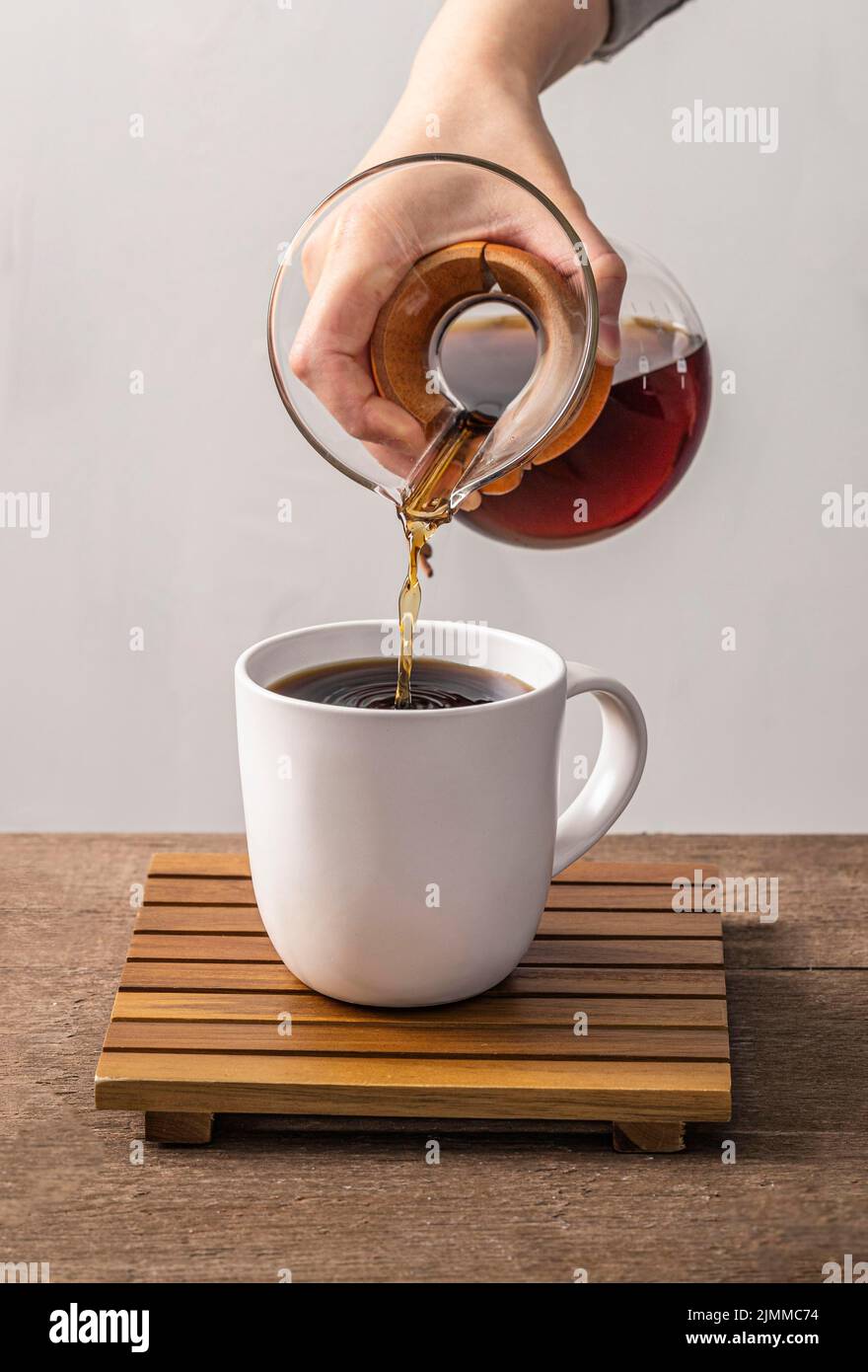 Front view hand pouring coffee into mug Stock Photo - Alamy