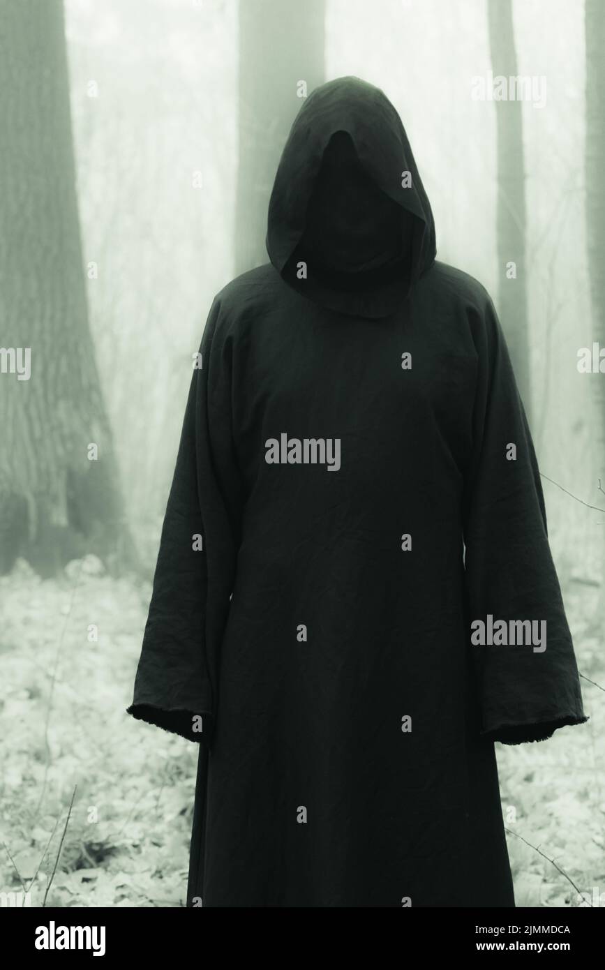 Death in a black hoodie in forest mist fog. Horror style fear spooky ...
