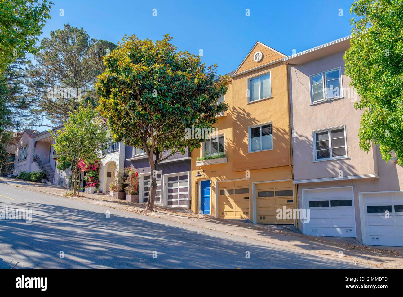 Sloped side walk and road with townhouses on the side in San Francisco ...