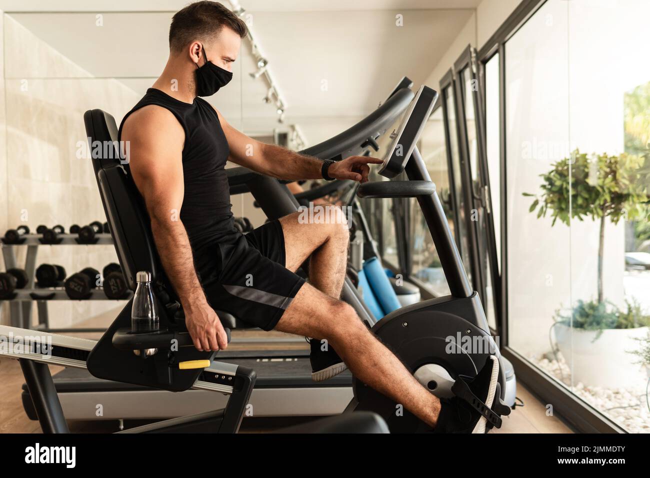 Athletic man wearing a prevention face mask during his workout in the ...