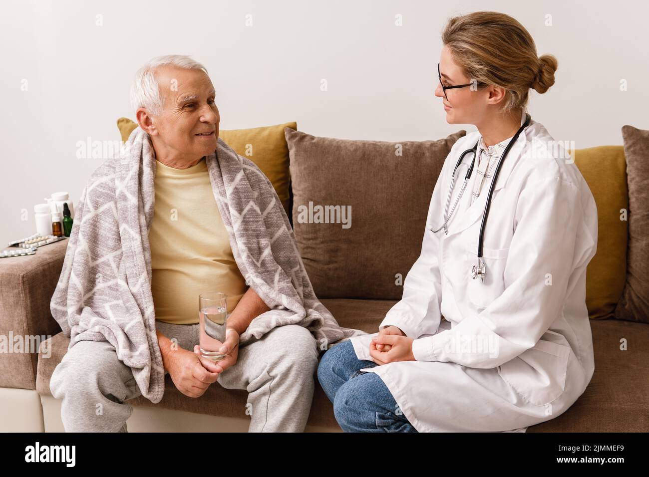 Doctor give a consultation to elderly man during home visit Stock Photo ...